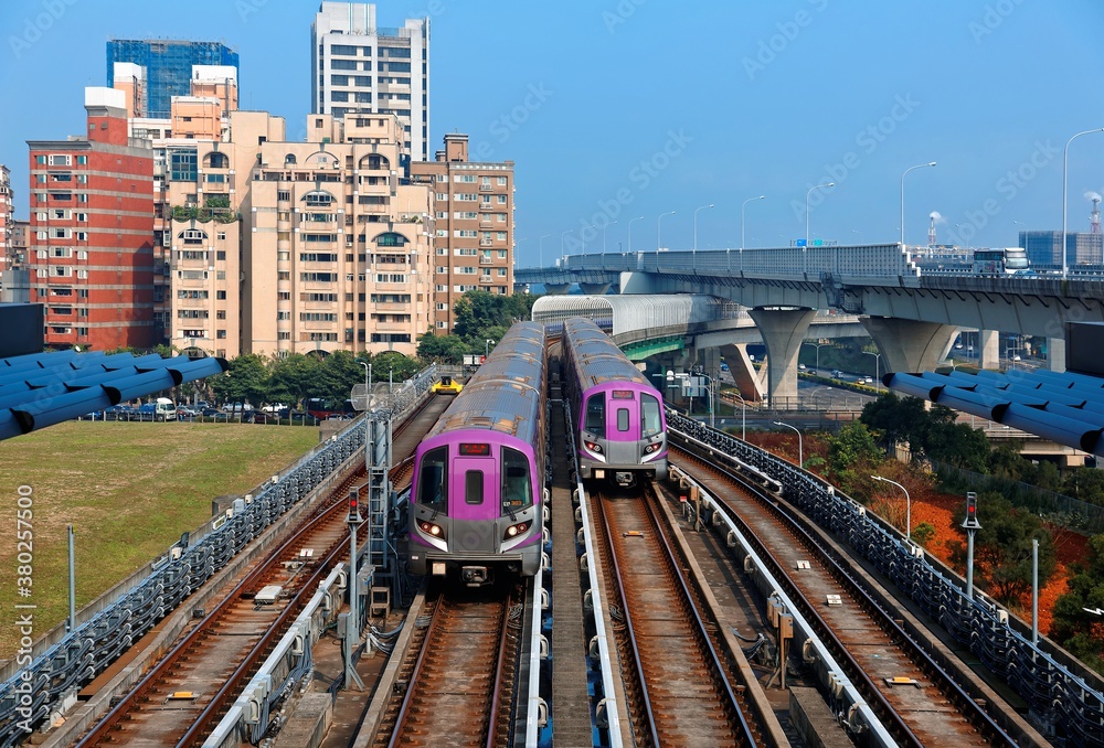 Cityscape with view of metro trains traveling on elevated rails of ...