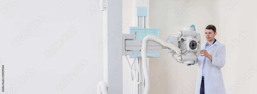 Young doctor radiologist adjusting the X-ray machine and preparing it ...