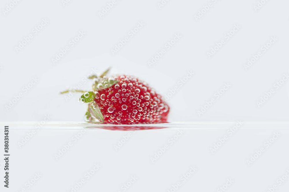 Photo of a strawberry floating in water flipped vertically to create a ...