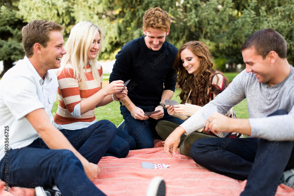 Friends playing cards in park Stock Photo | Adobe Stock