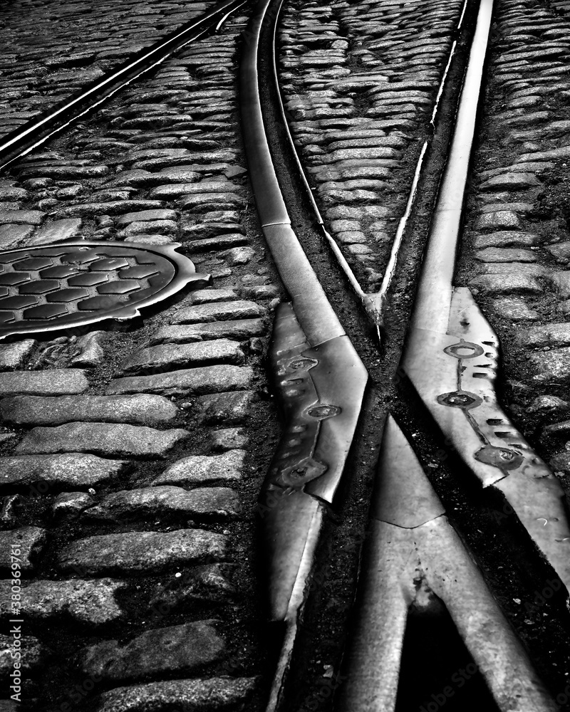 Vintage iron train tracks and manhole covers contrast with granite ...