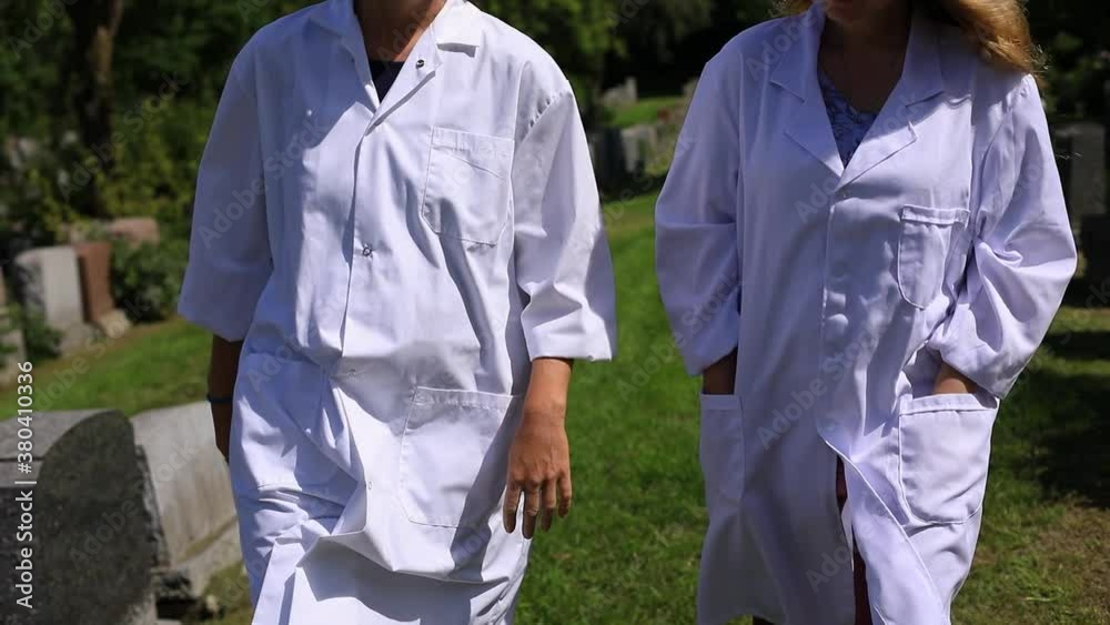 Selective focus of two young woman cemetery officers wearing medical ...
