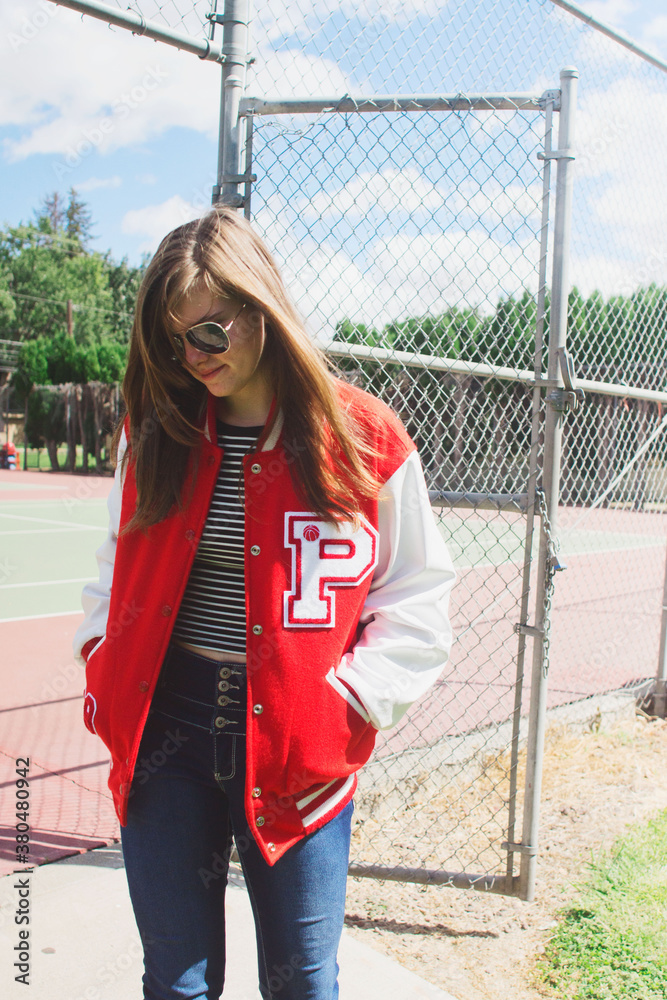 Teenage girl wearing Letterman jacket Stock Photo | Adobe Stock