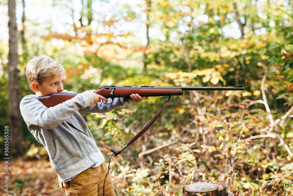 boy shooting a rifle in the forest Stock Photo | Adobe Stock