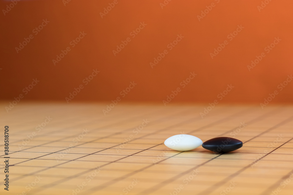 Black and white stones on the playing field (gohan) of Chinese game go ...