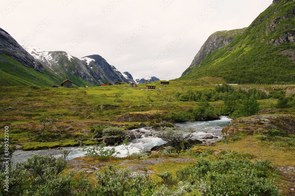 Norwegian valley landscape with hytter (cottages) in the background ...