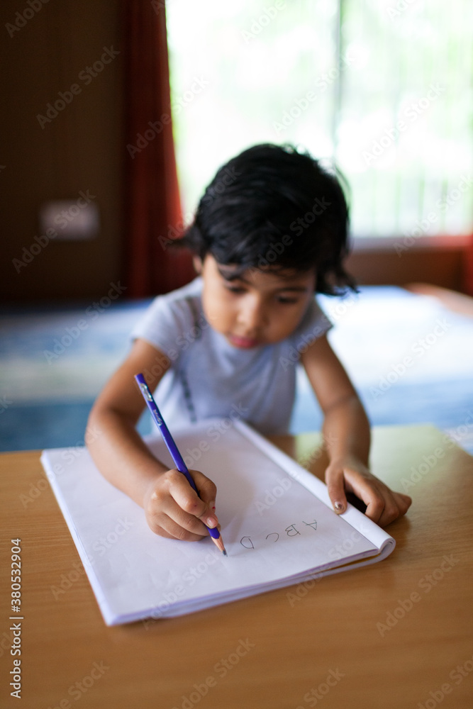 Little girl learning to write the english alphabets Stock Photo | Adobe ...
