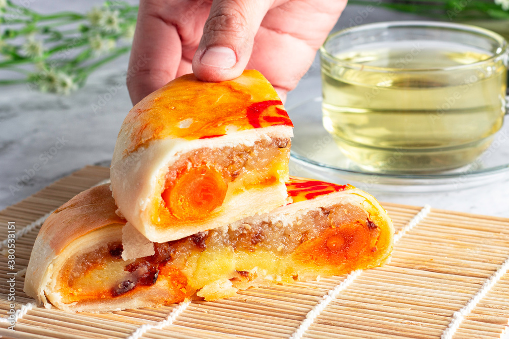 Hand are picking 1 piece of moon cake. Mooncakes cut into pieces and ...