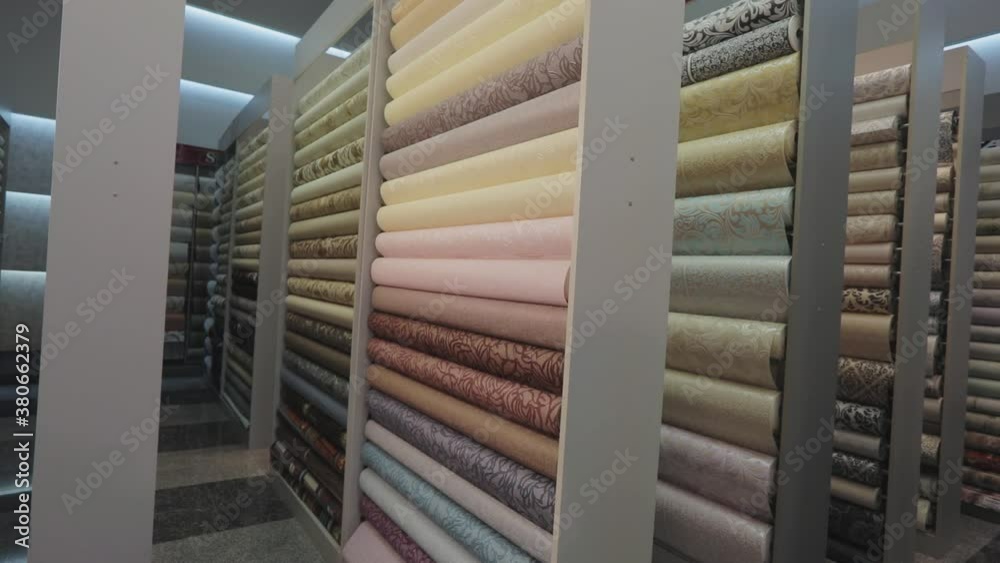 Stands with rolls of wallpaper samples in the store. Stands with new ...