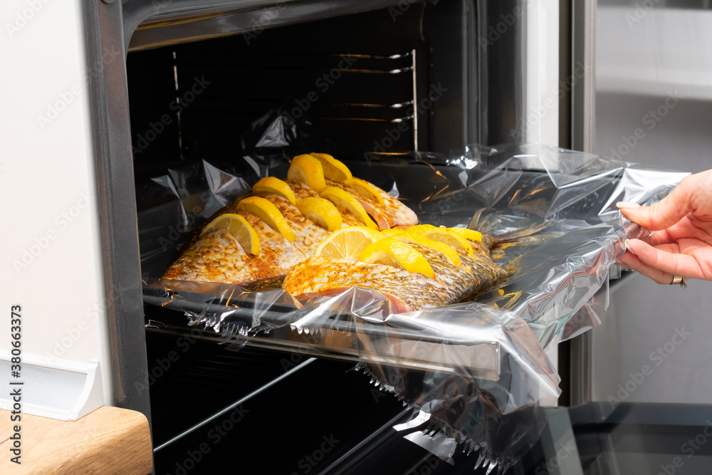 Bream fish in the oven. Open built-in convection oven in the kitchen ...