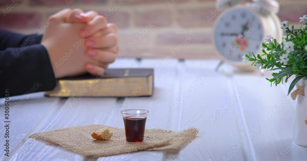 Young woman praying before taking communion - the wine and the bread ...