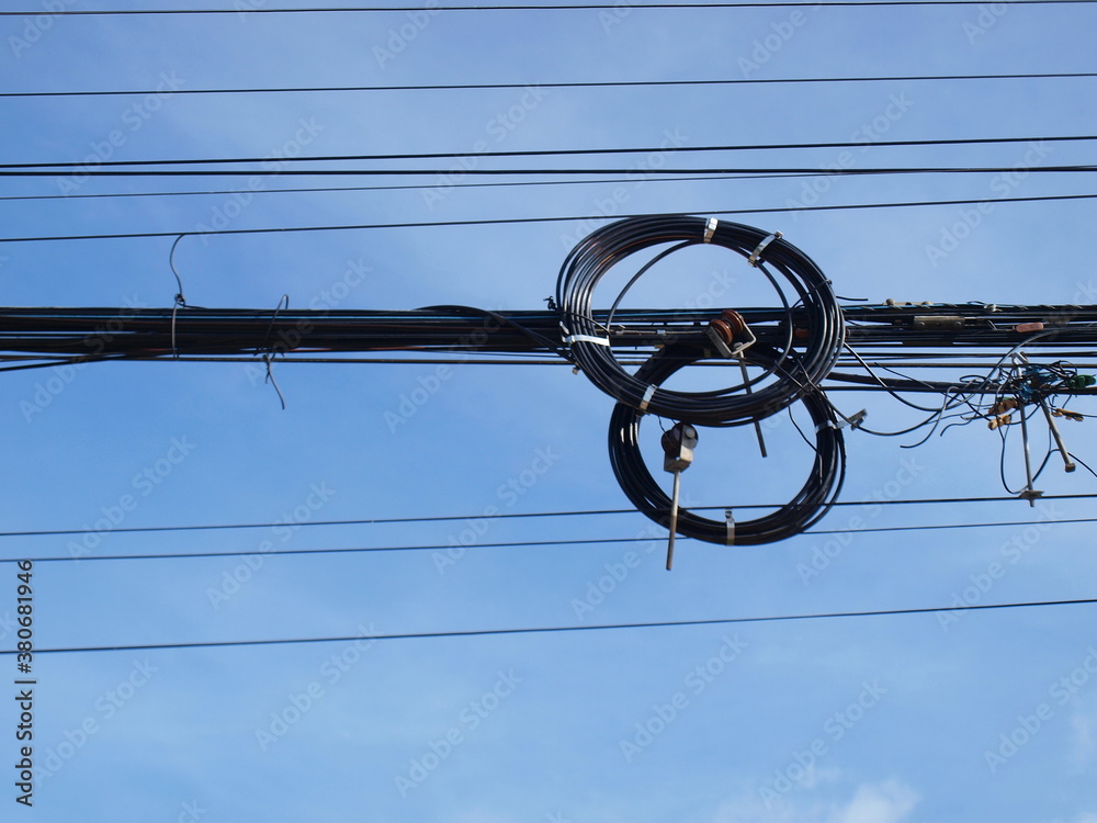 Black fiber optic cable reel hang on wire. Two coils of cable with ...