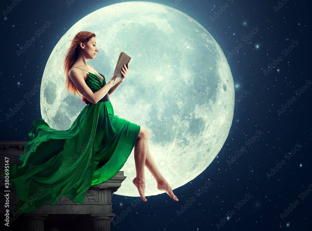 Beautiful woman reading a book sitting on rooftop on a moonlight sky ...
