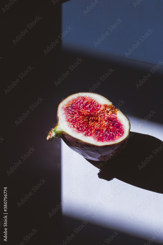 Cutted Fresh figs with shadows on dark and white background. contrast ...