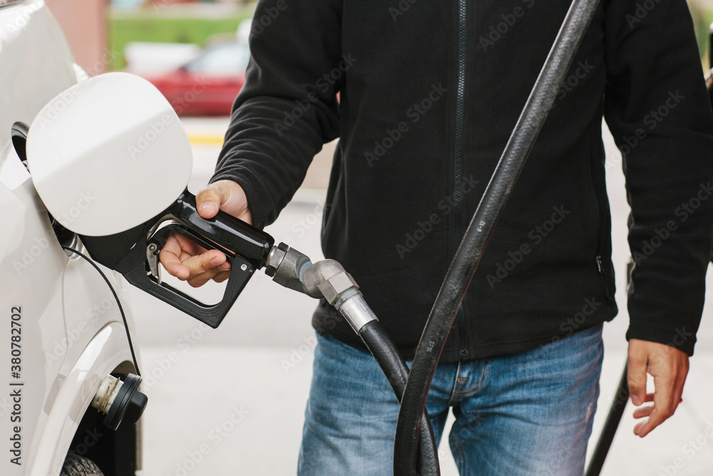 man pumps gas at a gas station Stock Photo | Adobe Stock