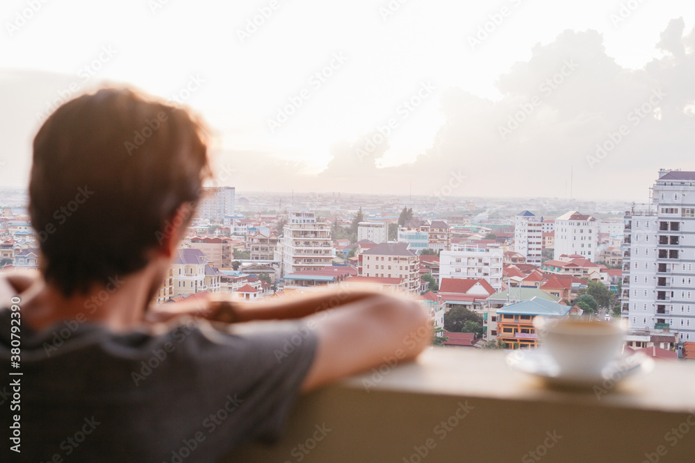 Young male on building rooftop looking out at city skyline Stock Photo ...