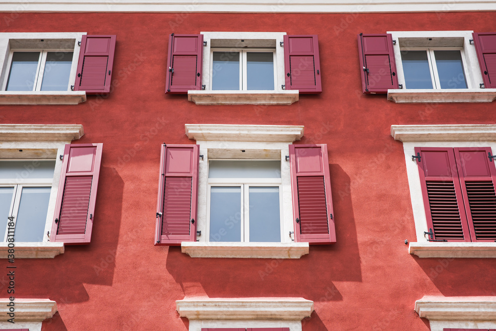 Bright colored house with white windows and pink shutters Stock Photo ...