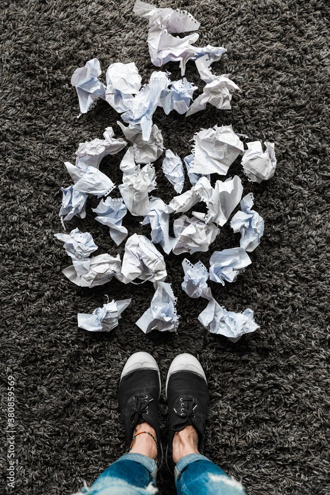 Looking down on woman's feet next to scrunched up writing paper Stock ...