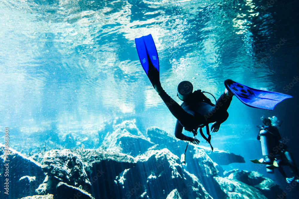 Back view of a scuba diver diving in a cenote in YucatÔøΩÔøΩn, Mexico ...