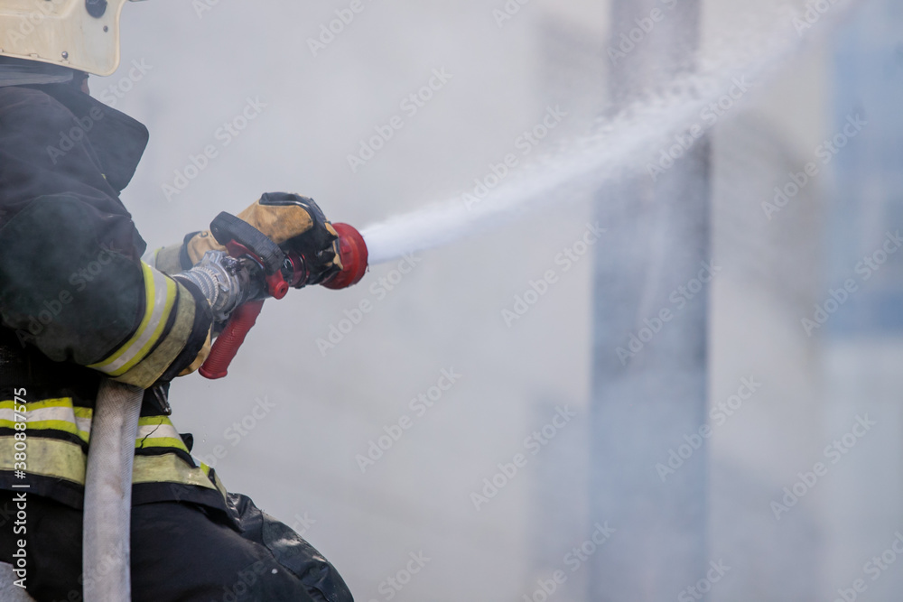 Firemen using extinguisher and water from hose for fire fighting in ...