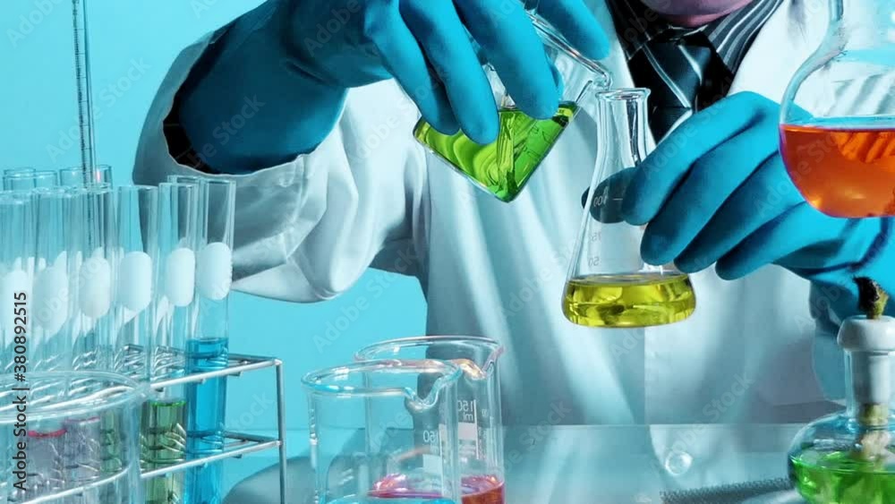 scientist holding flask with lab glassware and test tubes in chemical ...