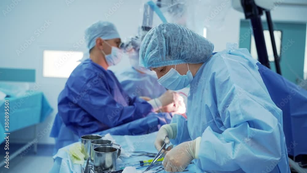 Group of doctors during neurosurgery. Medical assistant works with ...