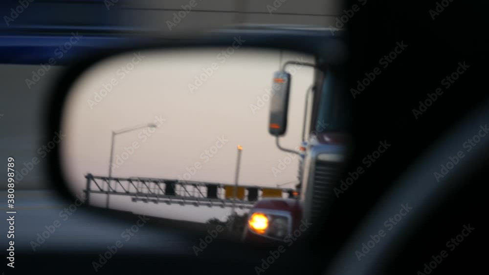 two shots of a red semi truck on the freeway. First shot is from the ...