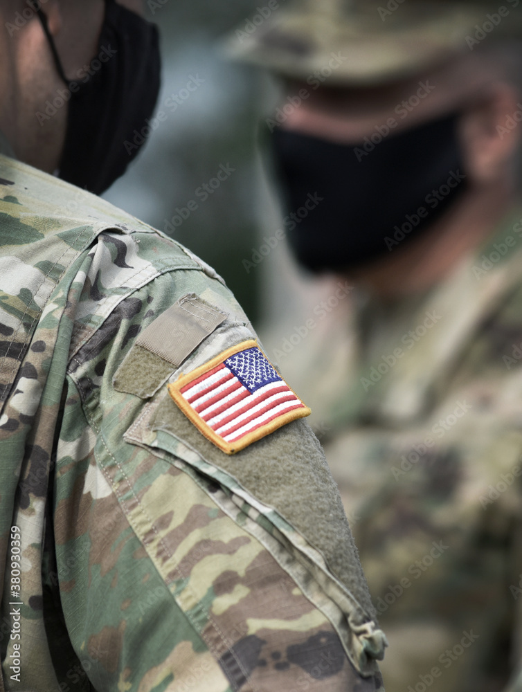 American flag on soldier arm and US soldiers wearing protective face ...