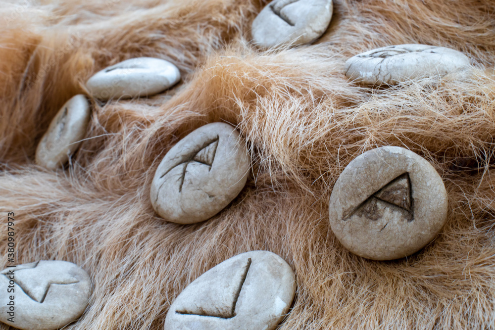 Stone runes on a animal fur. Futhark viking alphabet. Close up photo of ...