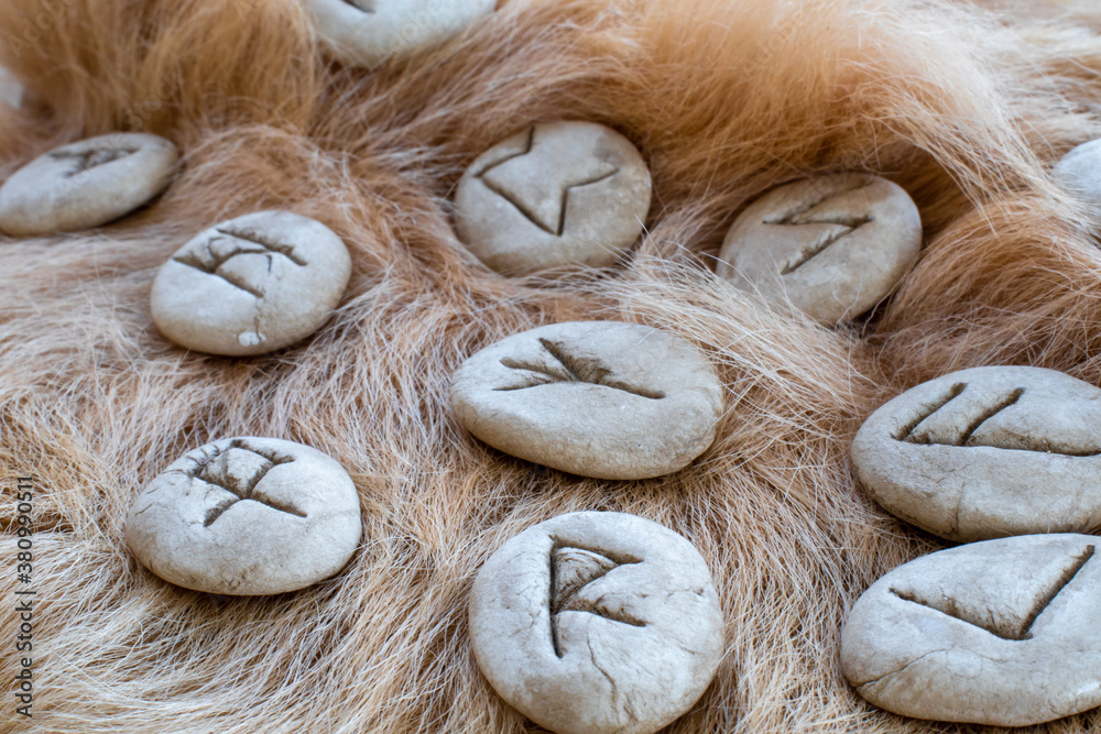 Stone runes on a animal fur. Futhark viking alphabet. Close up photo of ...