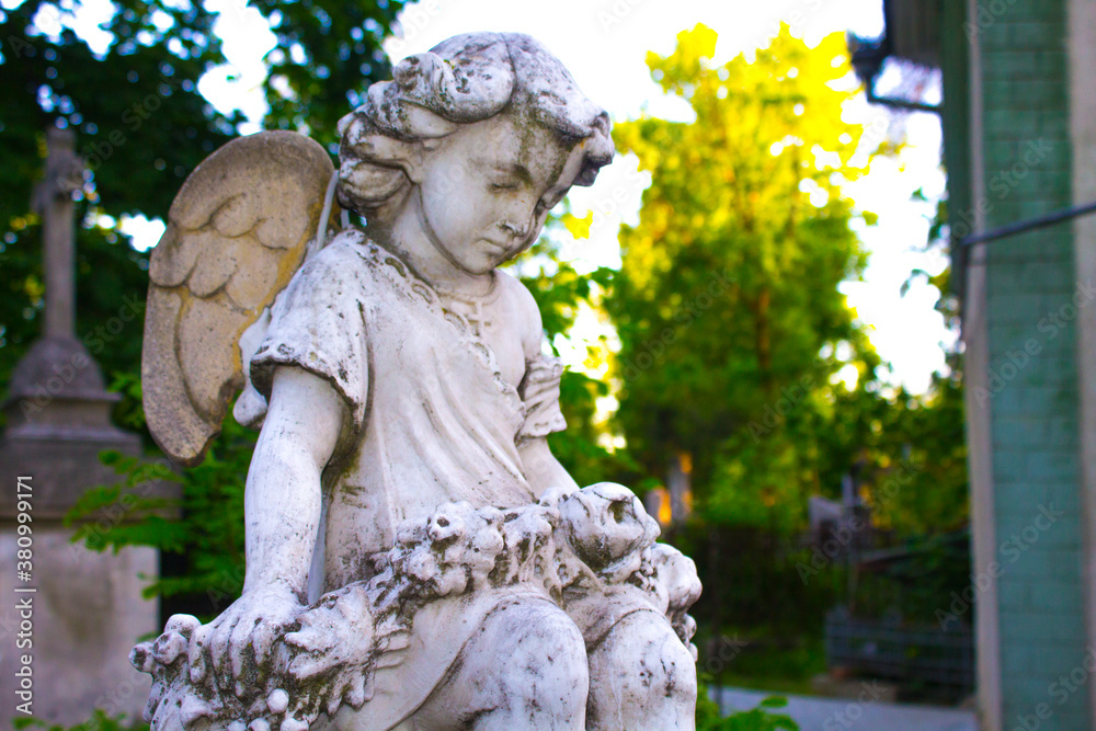 Figure of a praying angel. A very ancient stone statue. Death. Sad ...