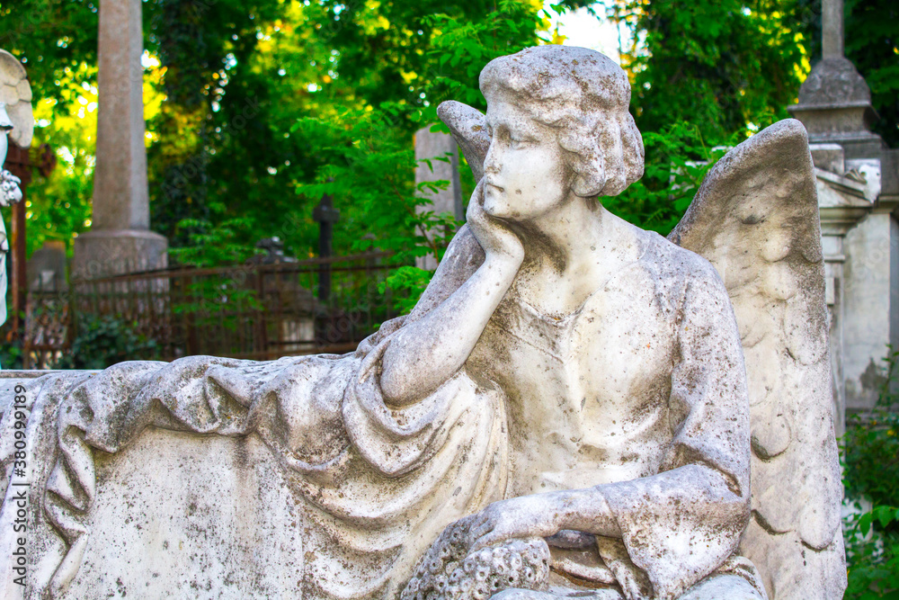 Figure of a praying angel. A very ancient stone statue. Death. Sad ...