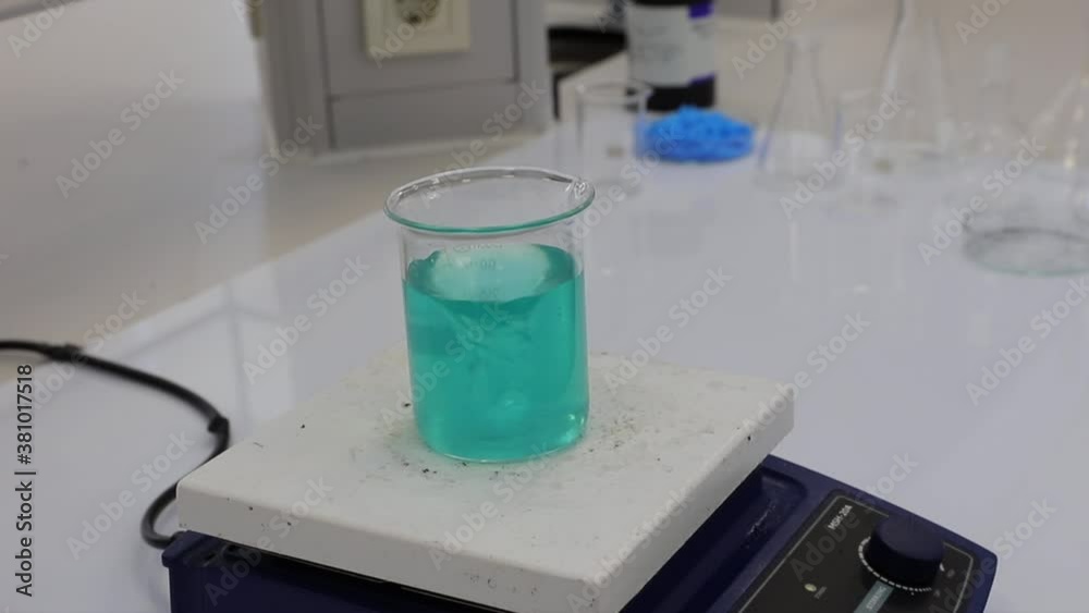 Cyan solution in a beaker is agitated with magnetic stirred in the laboratory Stock ビデオ | Adobe ...