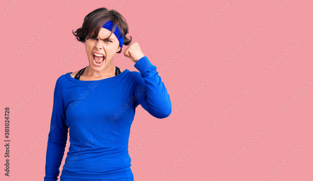 Beautiful young woman with short hair wearing training workout clothes ...