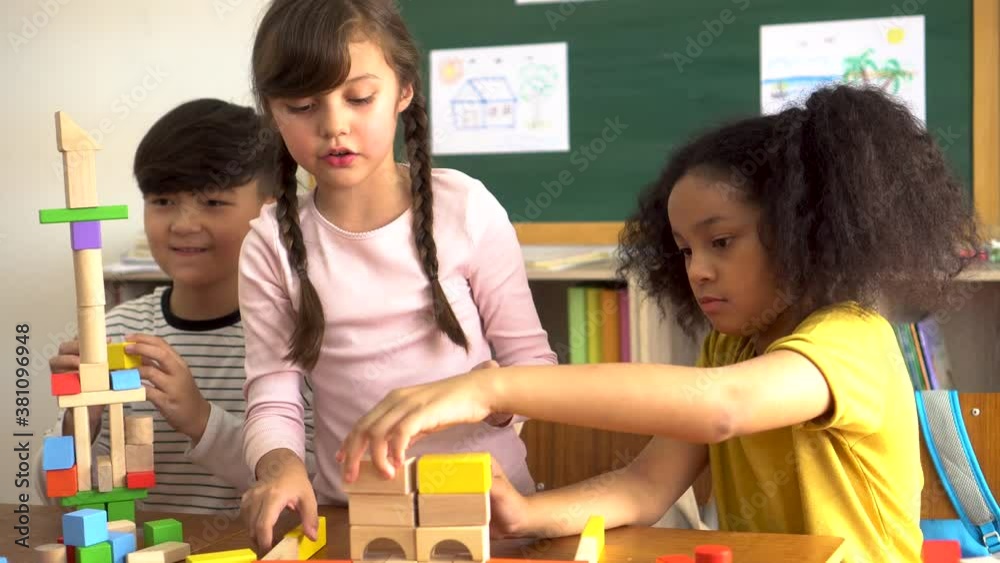 Group of multiethnic school friends using toy blocks in classroom ...