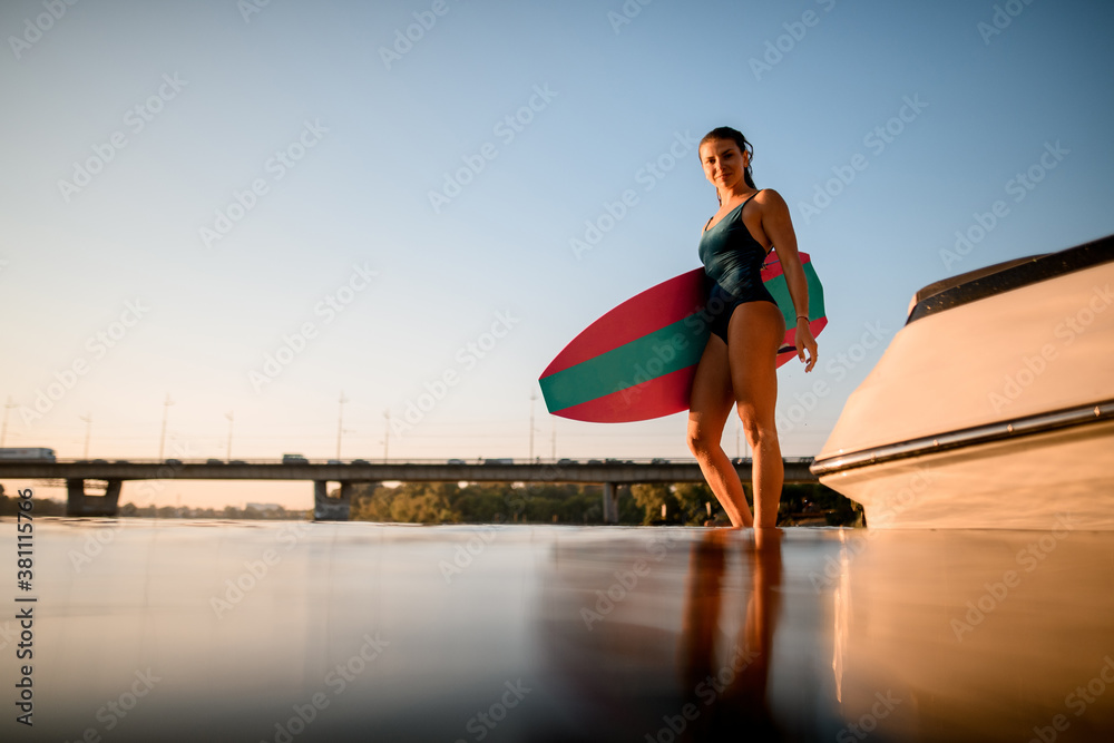 Beautiful Young Woman In Swimsuit With Surf Style Wakeboard Standing In