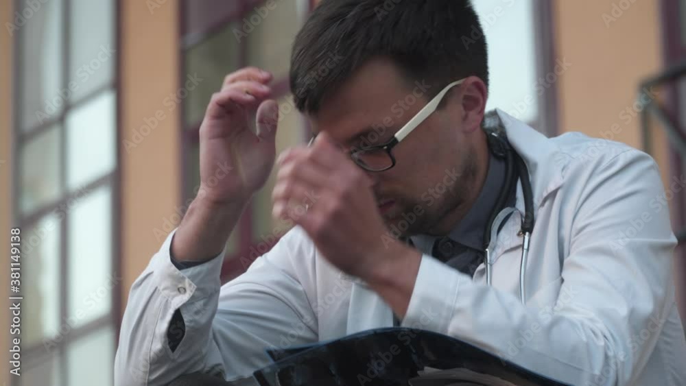 Wideo Stock: Worried tired doctor in white lab coat sit on floor ...