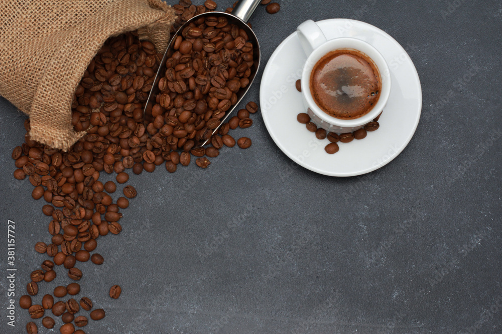 Freshly made black coffee cup with foam, beans in scoop scattered from ...