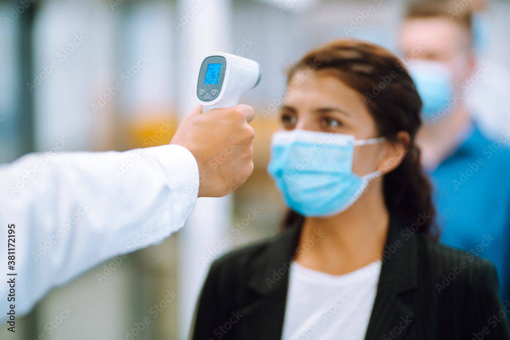 Disease control experts use an Infrared thermometer equipment to check ...