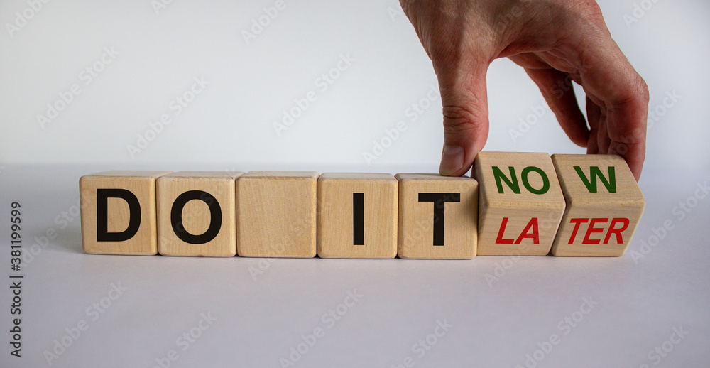 Male hand turns a cube and changes the expression 'do it later' to 'do ...
