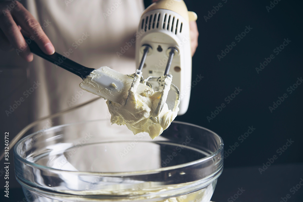 Lady is making cream cake using electric portable mixer machine Stock ...