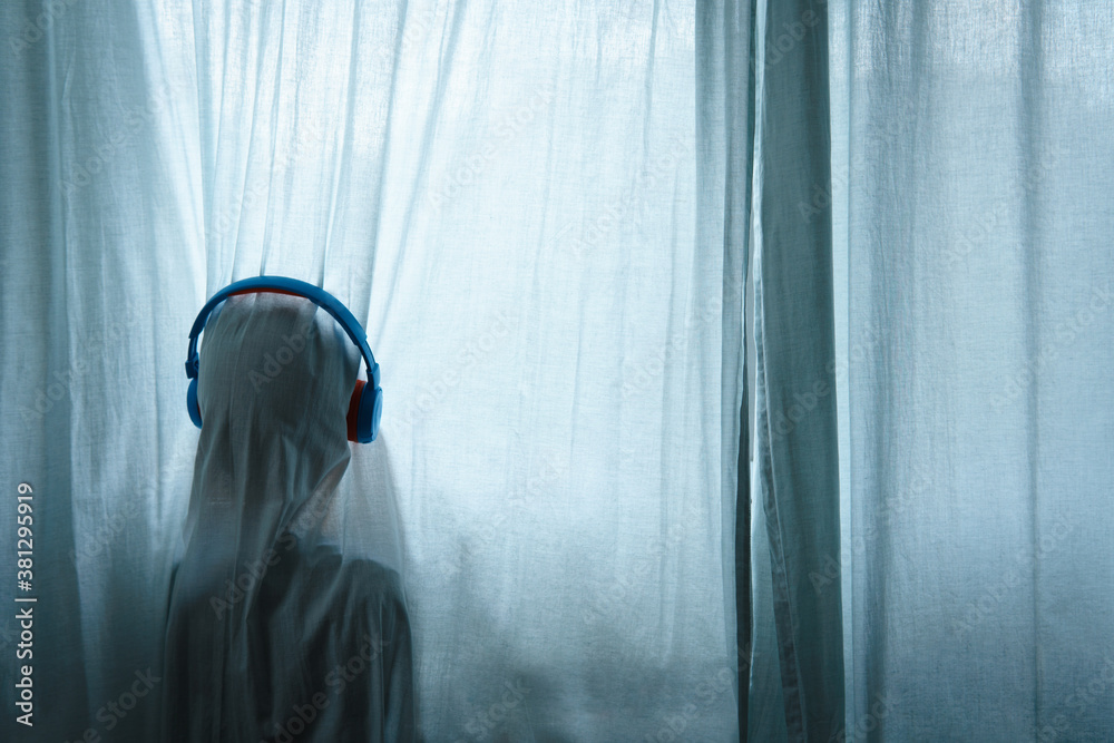 Portrait of autistic child stand alone, look out the window, wear ...