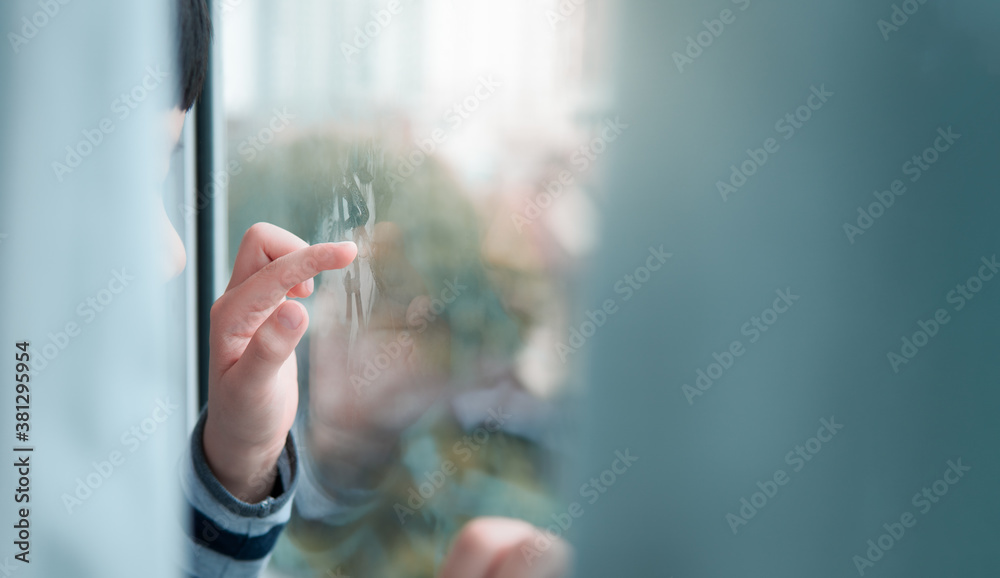 An Autistic child draw stick figure with finger on fogged glass window ...