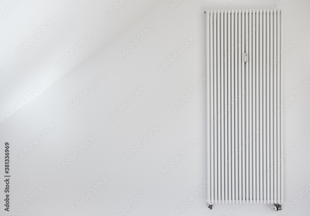 Heating with a long tubular radiator on the wall of an apartment Stock ...