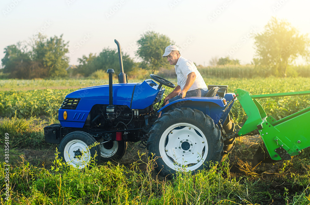 A farmer on a tractor prepares to enter the field and start harvesting ...
