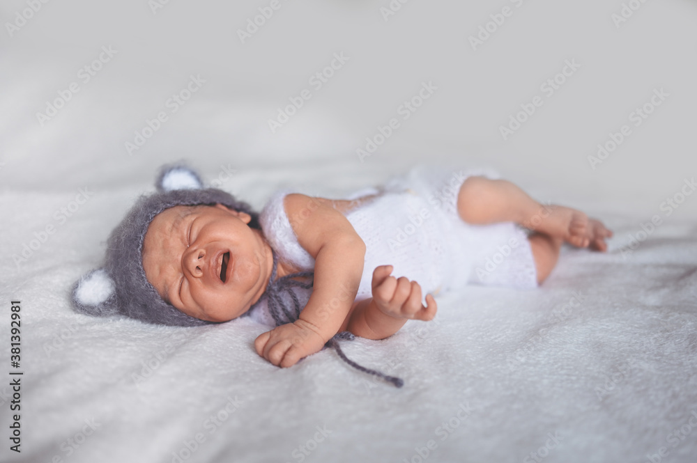Cute crying newborn little baby boy sleeping in crib in a knitted suit ...
