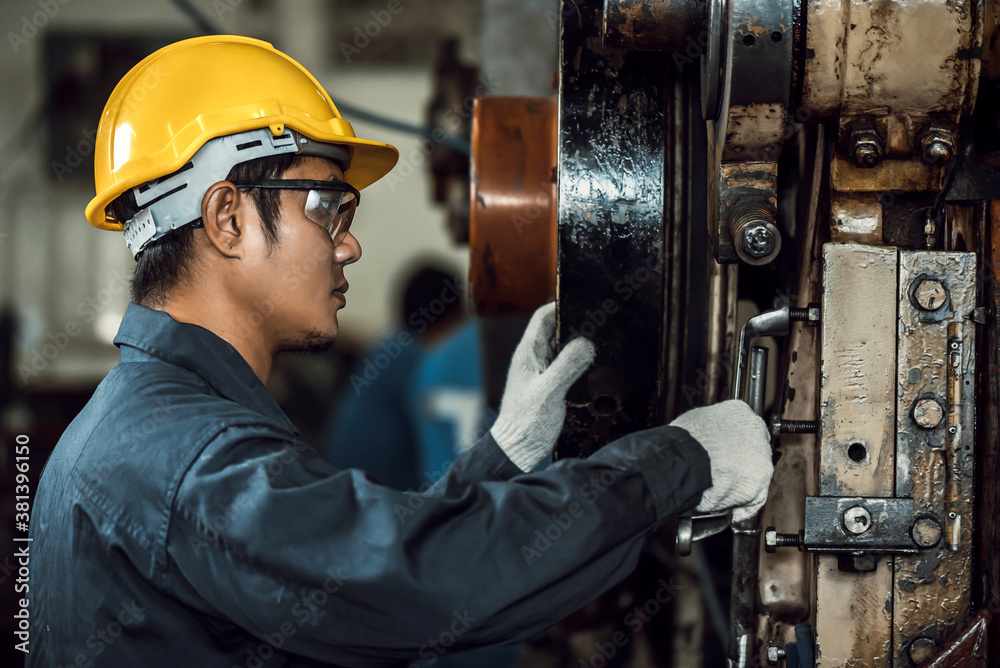 Foto de mechanic man checking and repair metal work pressing machine at ...