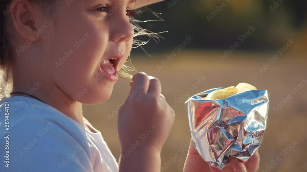 child eating chips close-up face. kid resting in the park eating chips ...