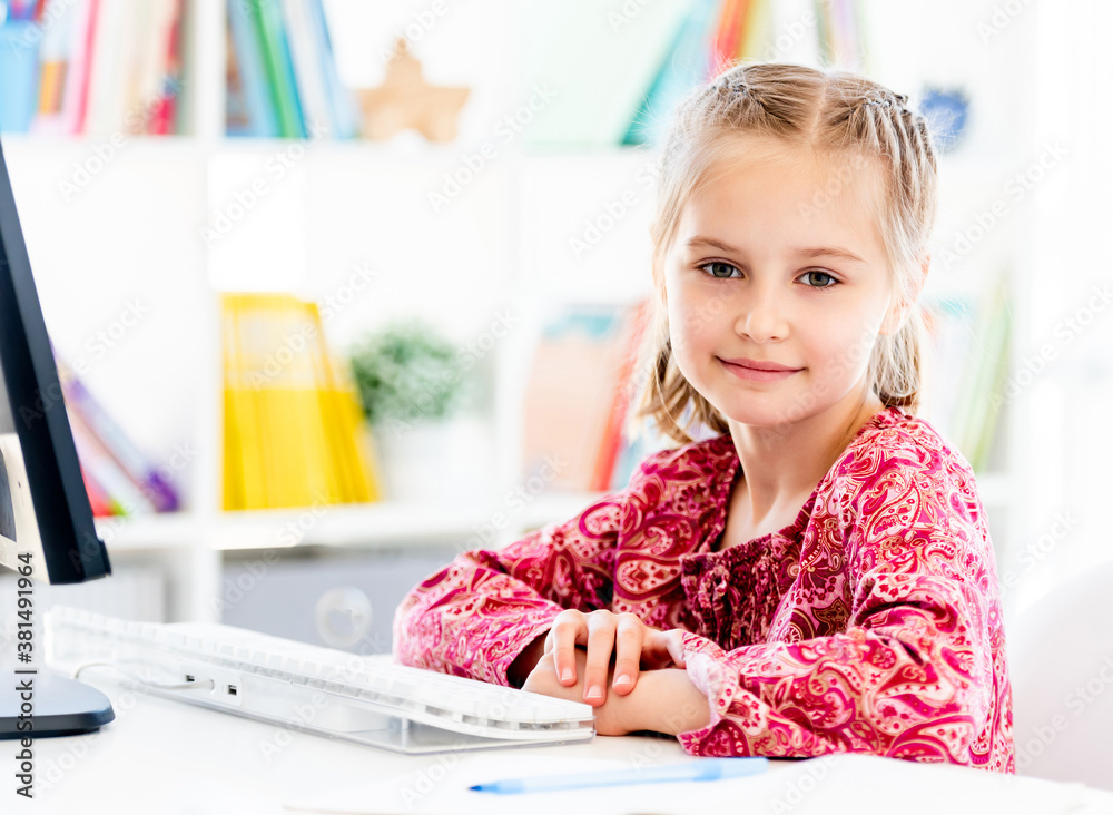 Little girl sitting in front of computer Stock Photo | Adobe Stock