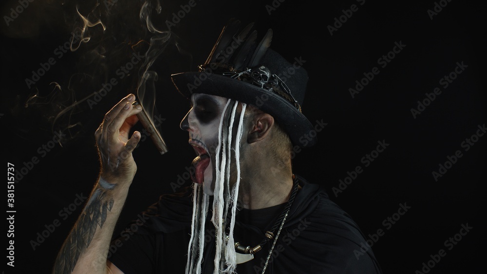 Scary guy in carnival costume of Halloween skeleton smoking cigar ...